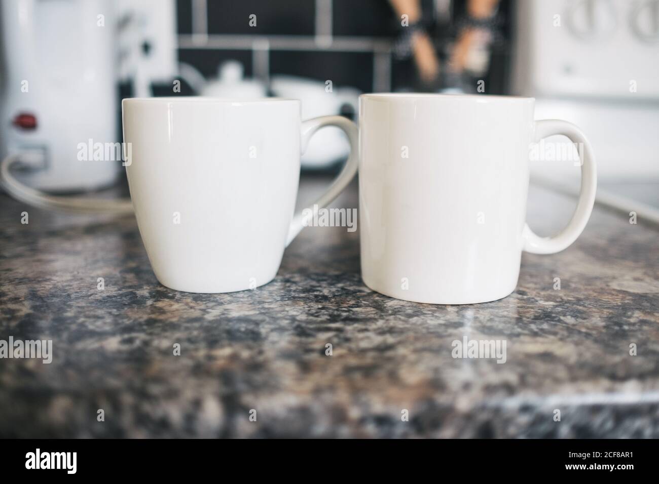 Big white mugs with drink at marble table during breakfast in kitchen ...