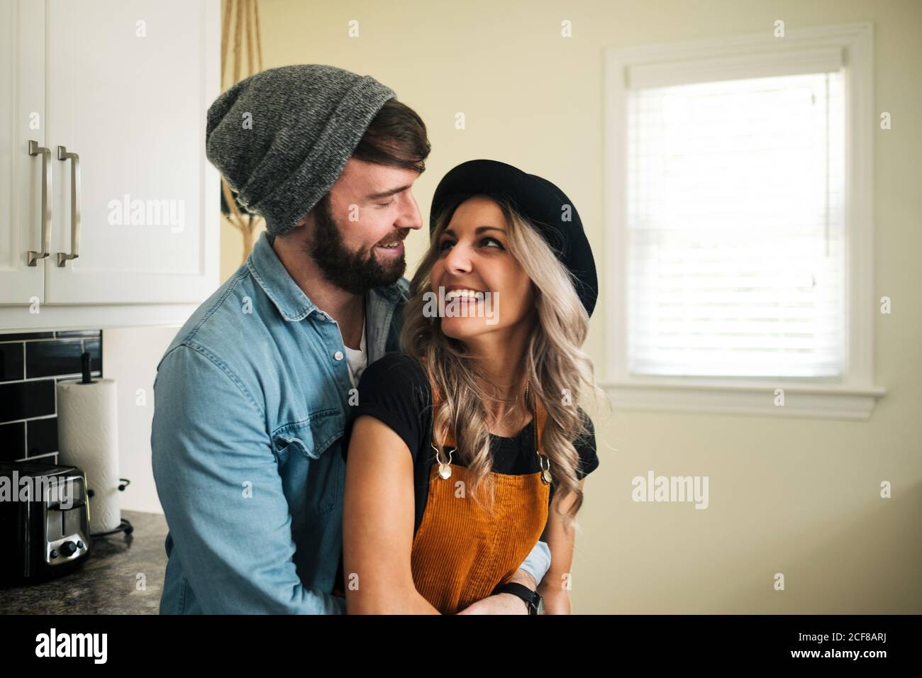 Side view of cheerful Woman in hat and smiling boyfriend in denim ...