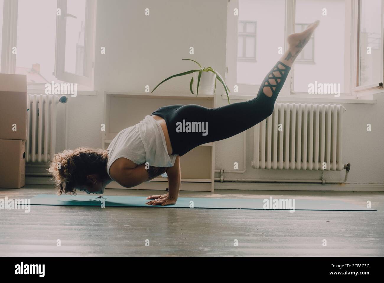 Side view of flexible Woman in activewear exercising and standing on ...