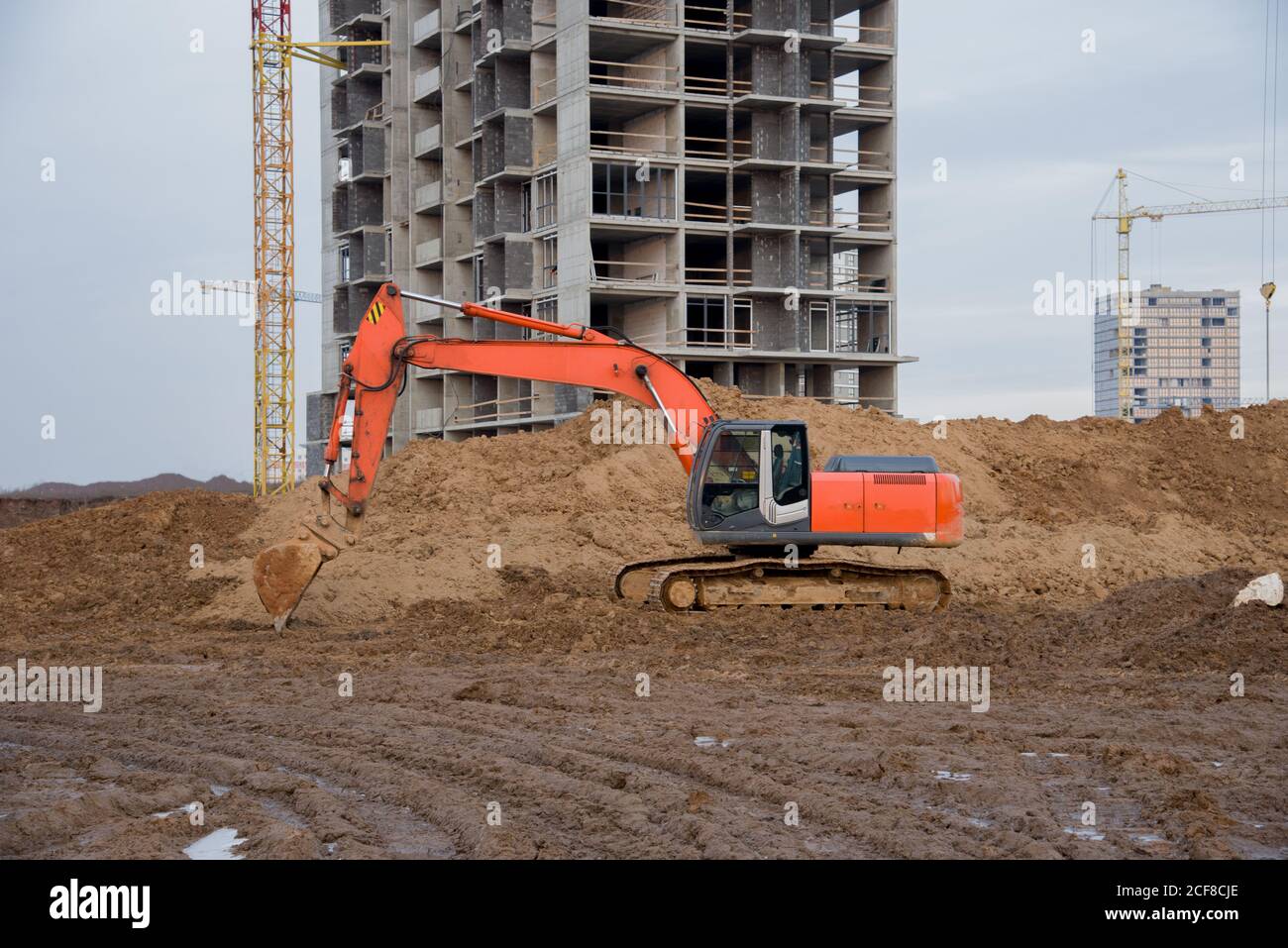 Excavator at building under construction. Backhoe digs the ground for ...