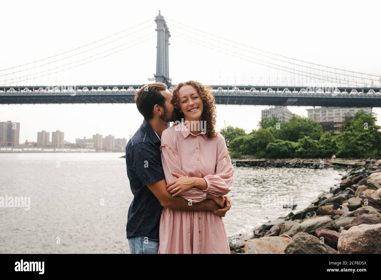 Side view of boyfriend and girlfriend embracing while standing on ...