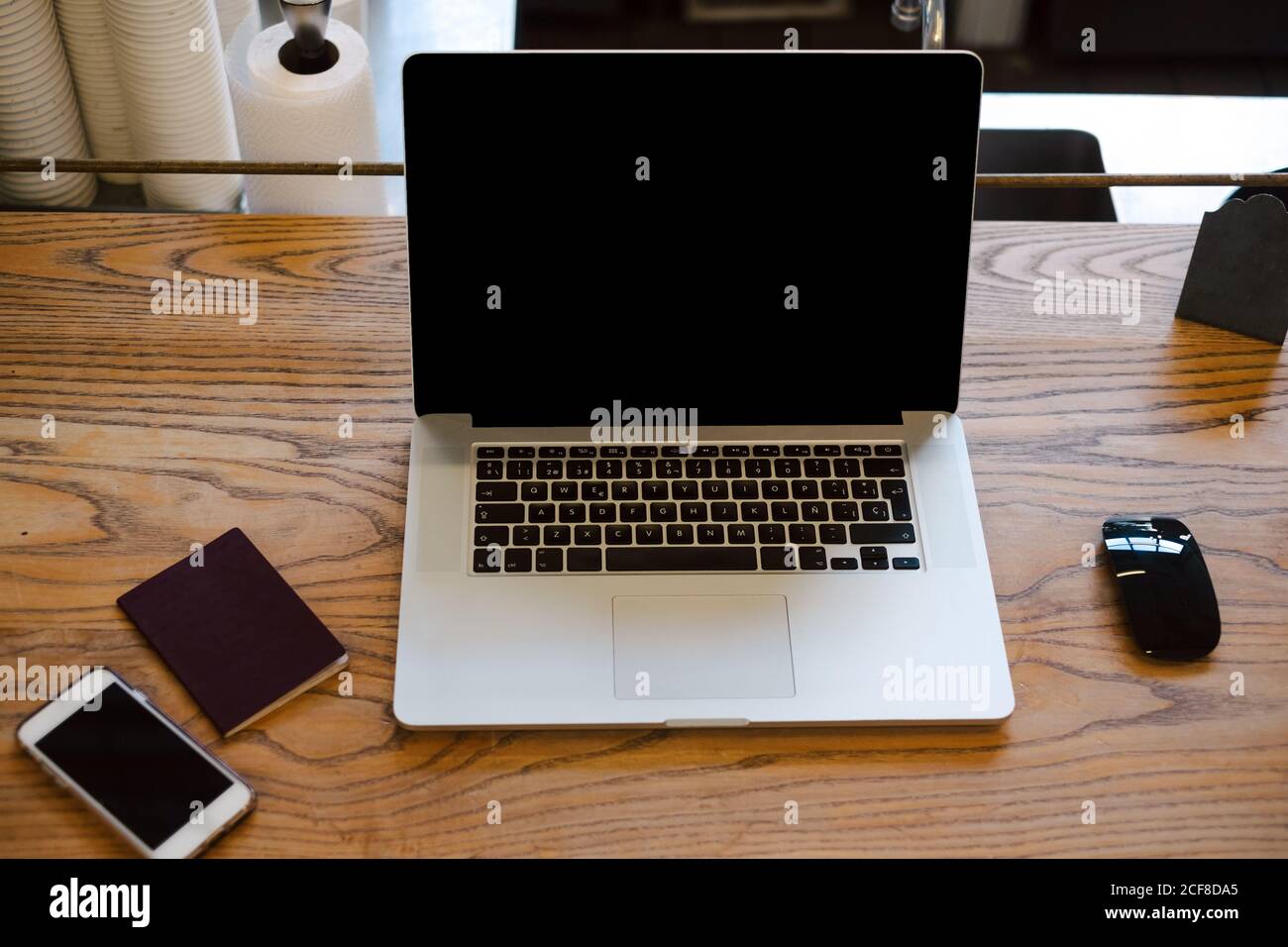 Modern netbook placed on wooden table with smartphone and mouse in cozy ...