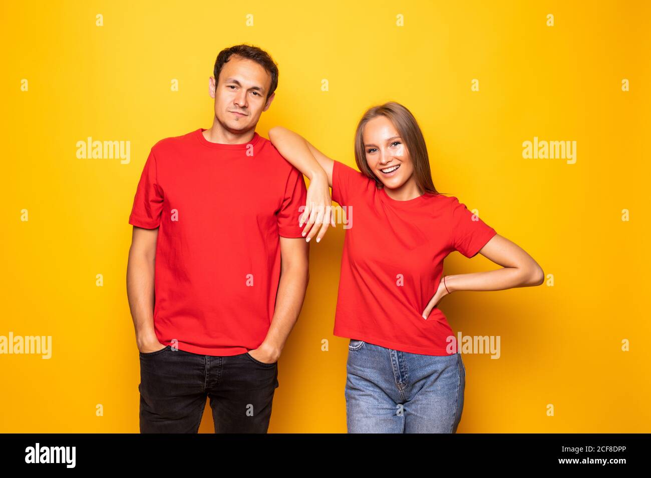 Portrait of cool couple in red shirts looking at camera isolated on ...