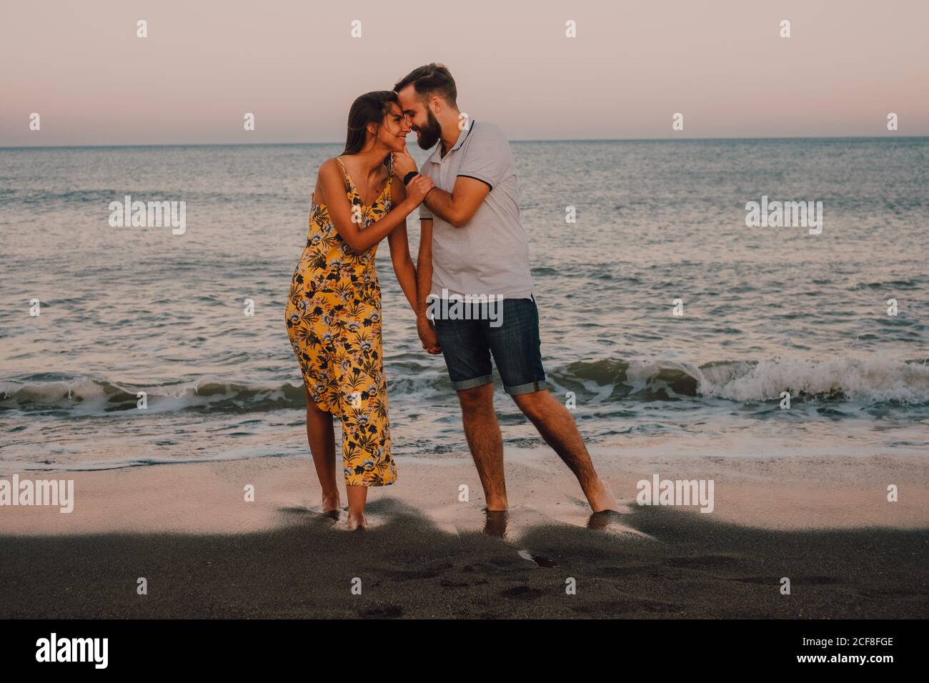 Amorous man hugging Woman while charming lady looking gently at seaside ...