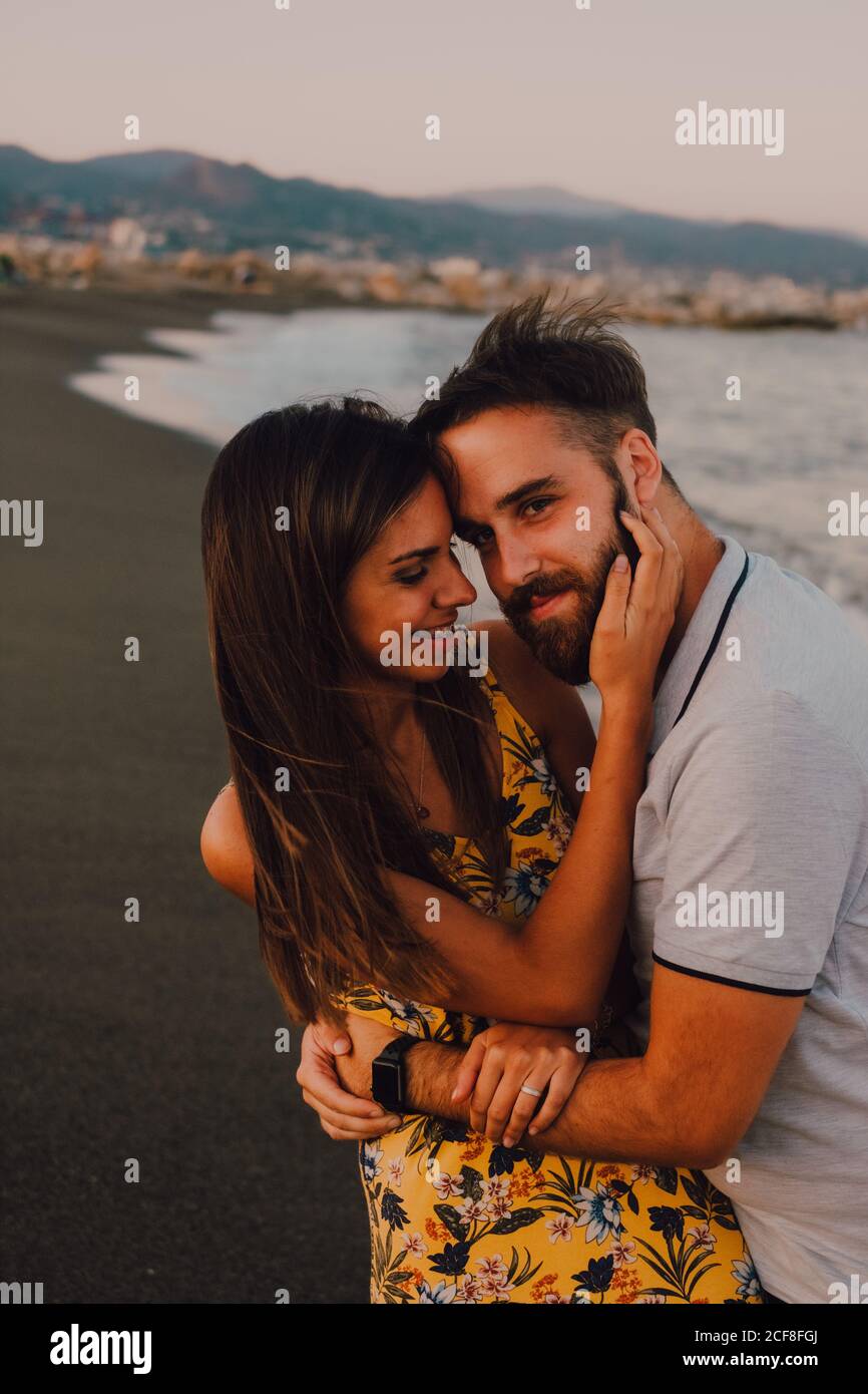 Amorous man hugging Woman while charming lady looking gently touching ...