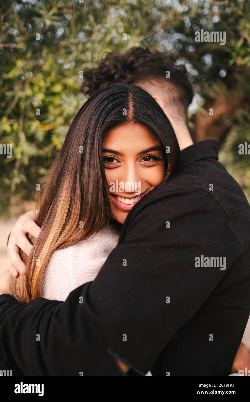 Side View Of Tender Multiracial Couple In Stylish Wear Standing In