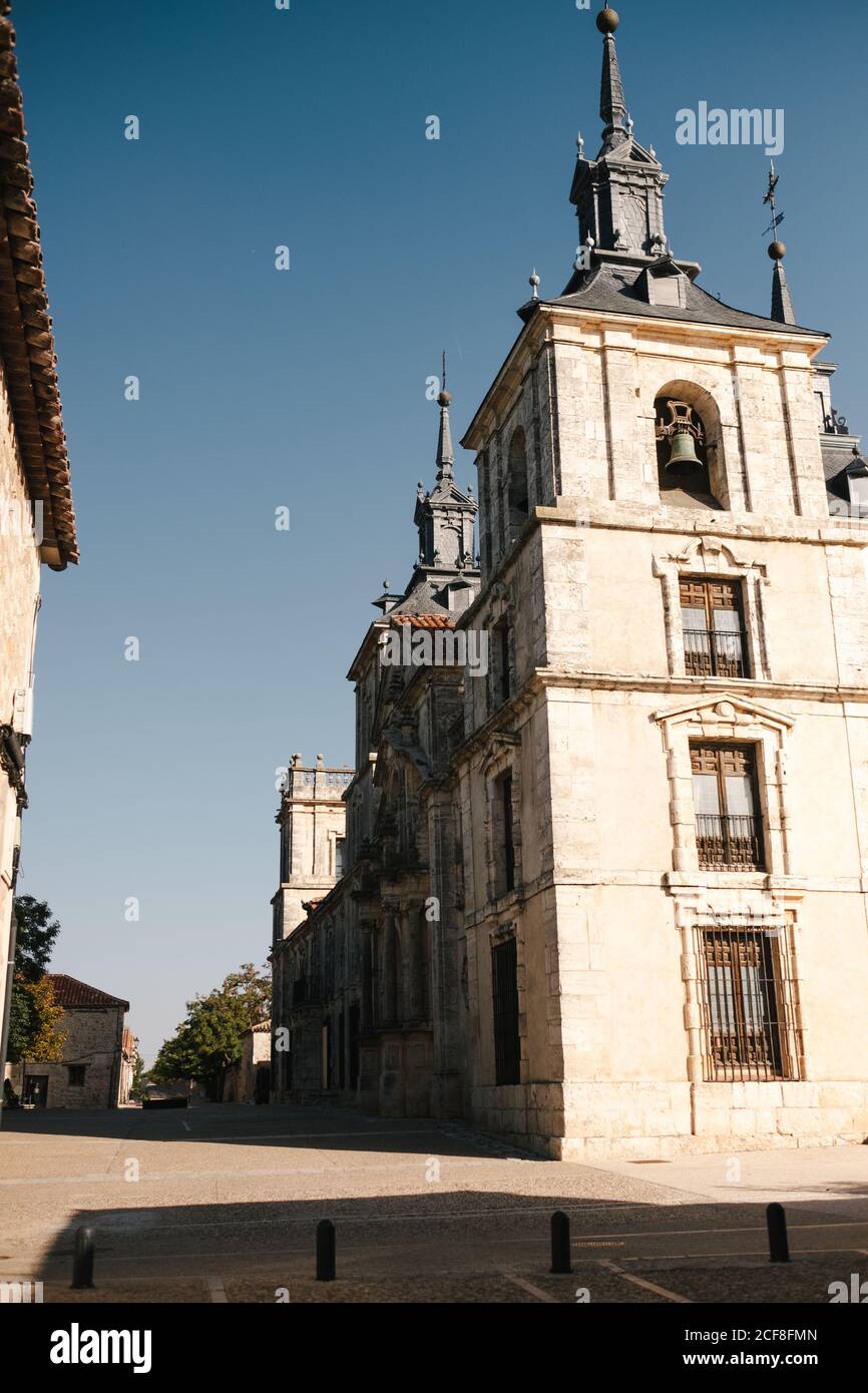 Low angle exterior of aged stone monastery building with bell tower ...