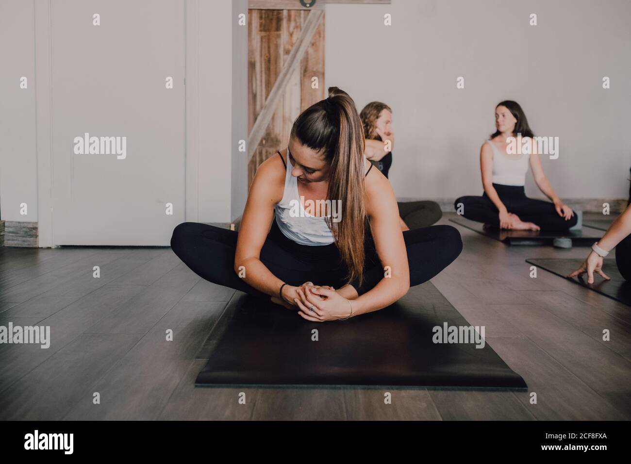 Diligent barefooted Woman in sportswear performing bound angle pose ...
