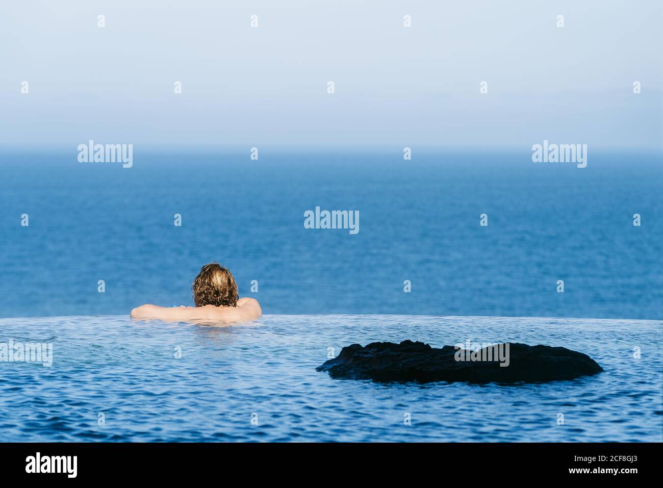 Back view of male tourist leaning on poolside and admiring majestic ...
