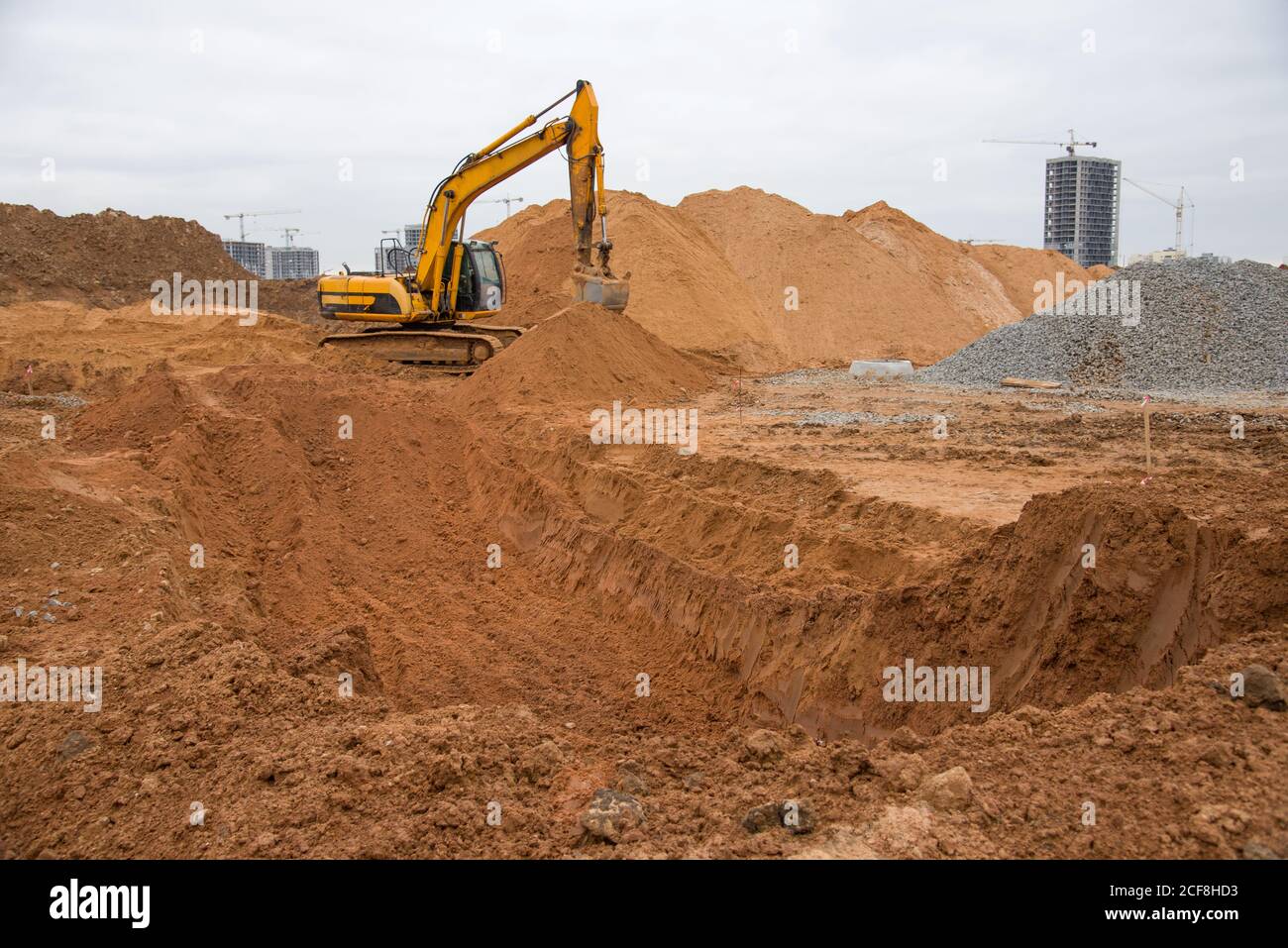Excavator at earthworks on construction site. Backhoe loader digs a pit ...