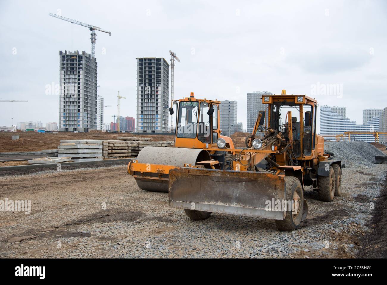 Motor Grader and Soil Compactor at a construction site level the ground ...