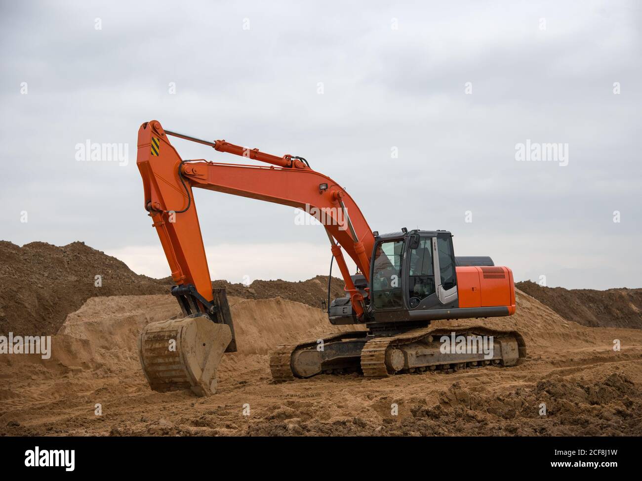 Track-type excavator during earthmoving work at open-pit mining. Loader ...