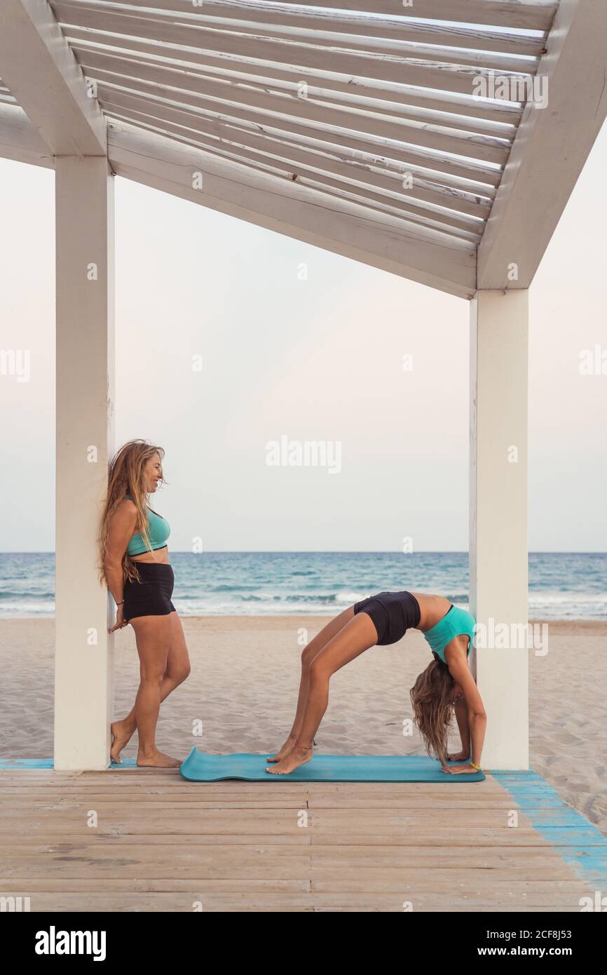 Partner looking at Woman making bridge in acroyoga on background of ...