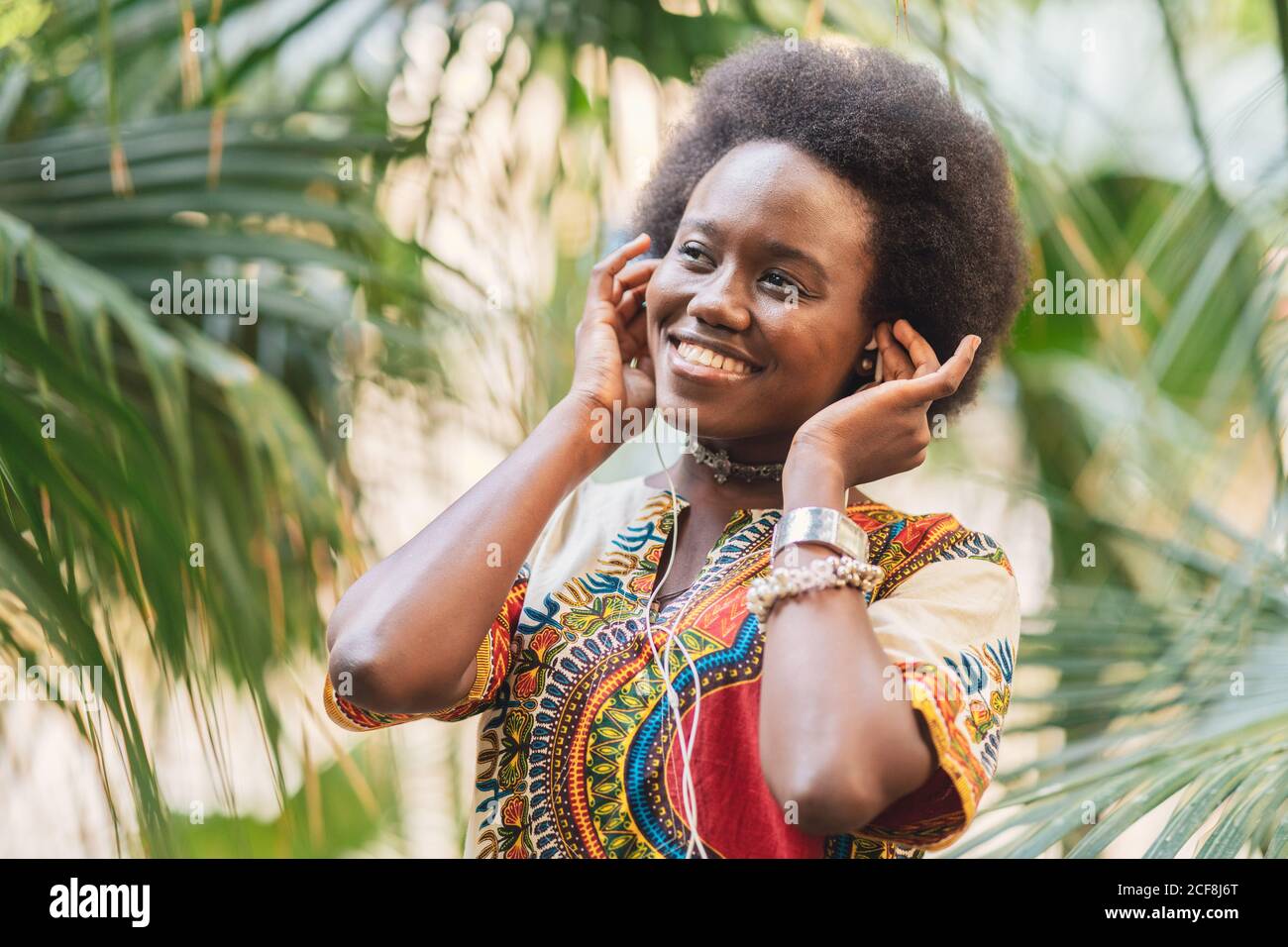Smiling black Woman listening to music Stock Photo - Alamy