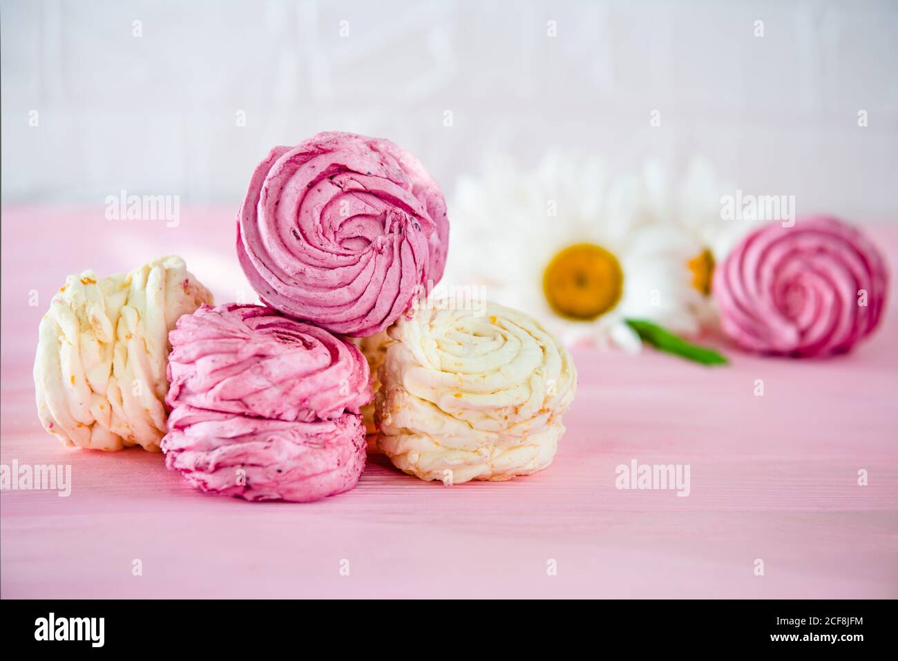 Apple and raspberry zephyr on pink background. Sweet confectionery ...