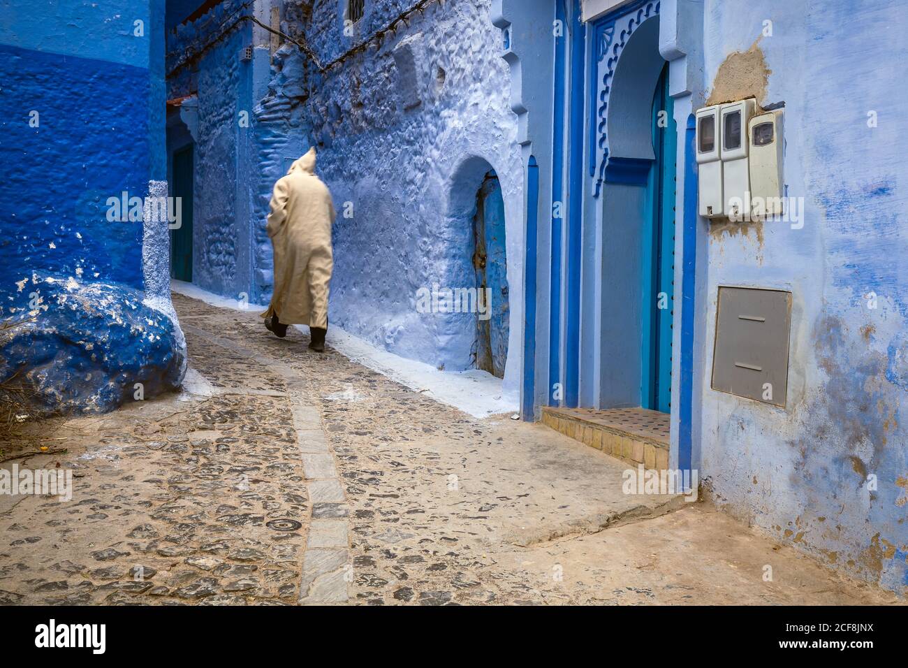 Man wearing traditional clothes walks in the famous blue city of ...
