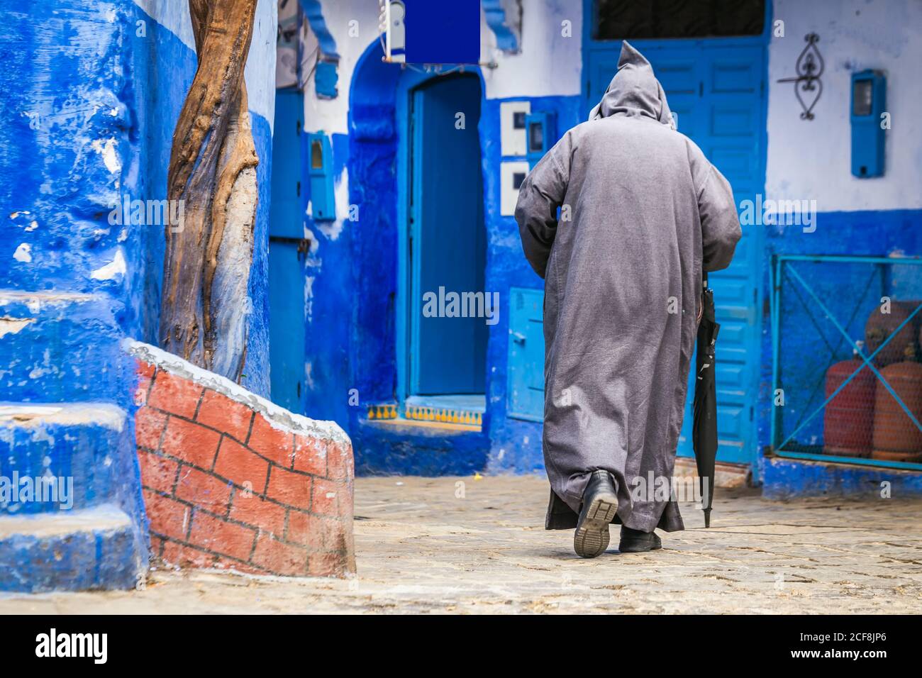 Man wearing traditional clothes walks in the famous blue city of ...