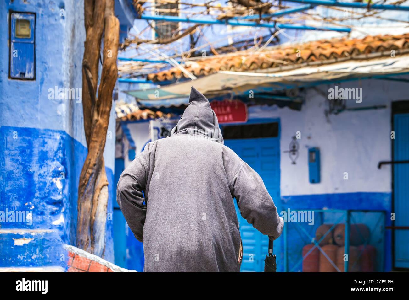 Man wearing traditional clothes walks in the famous blue city of ...