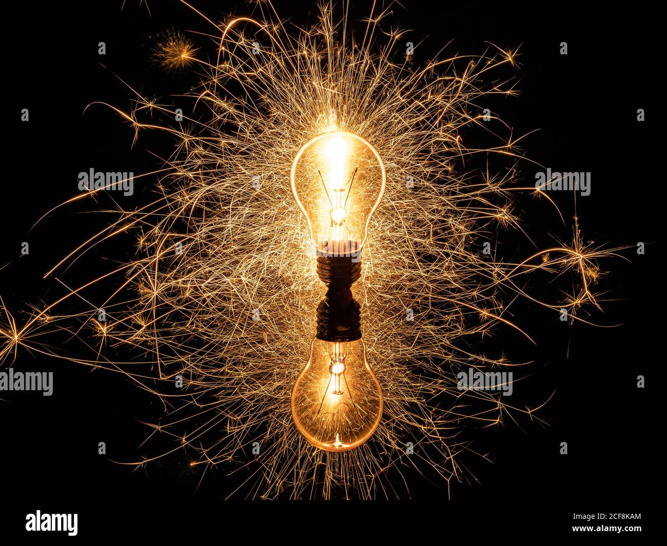 Light bulb with sparklers from behind on black background Stock Photo ...