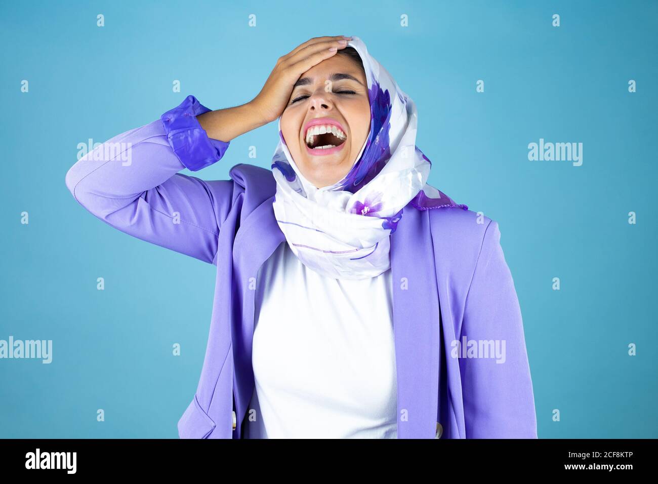 Young beautiful arab woman wearing islamic hijab over isolated blue ...