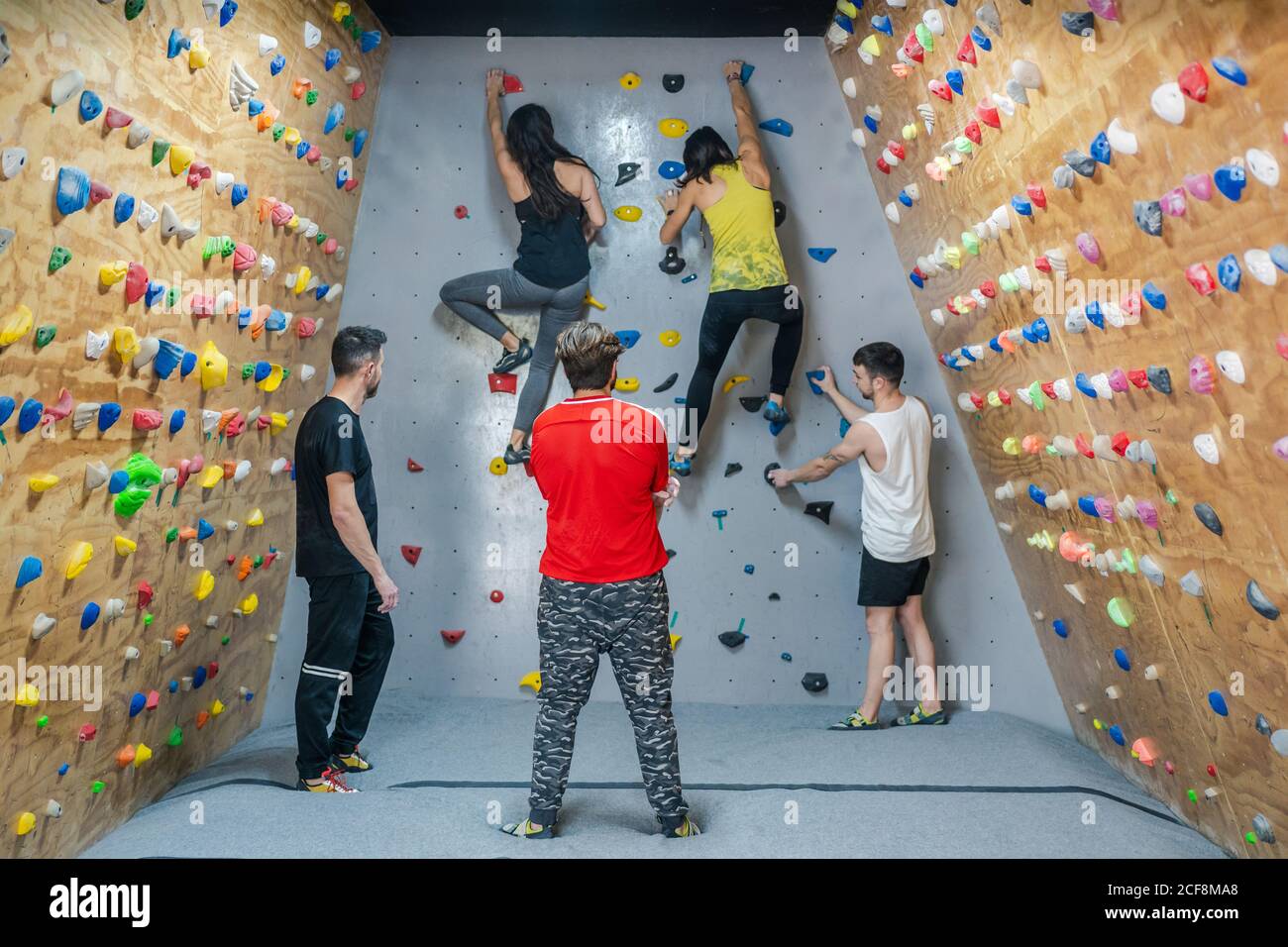 Back view of young group of strong male and female climbers having ...