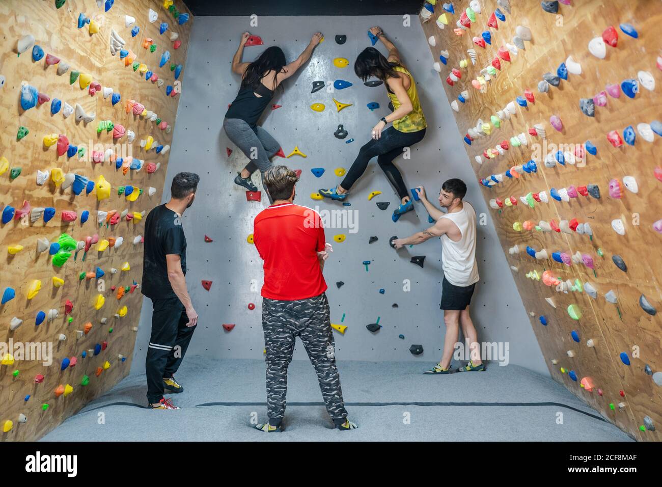 Back view of young group of strong male and female climbers having ...