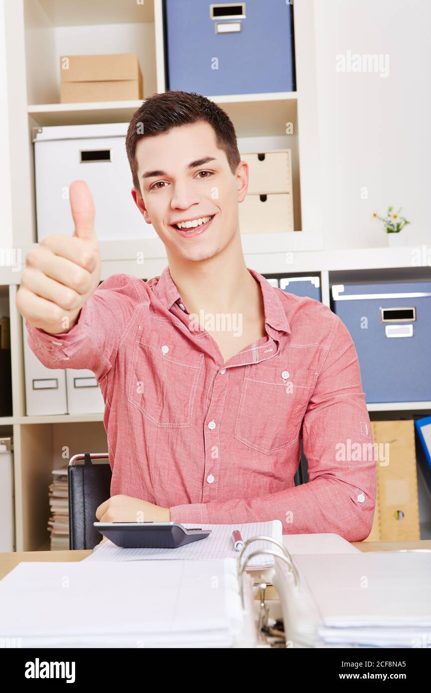 Student laughing while studying holds his thumb up Stock Photo - Alamy