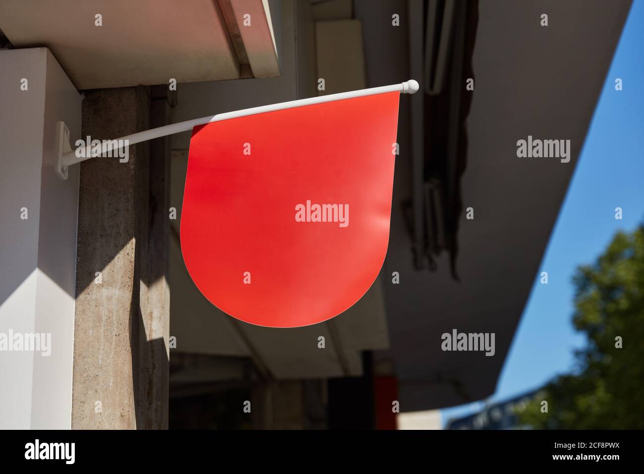 Red flag as an advertising mock-up hangs on the wall of a shop Stock ...