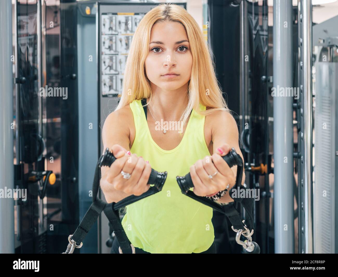 Athletic young lady in sportswear looking at camera and doing chest ...