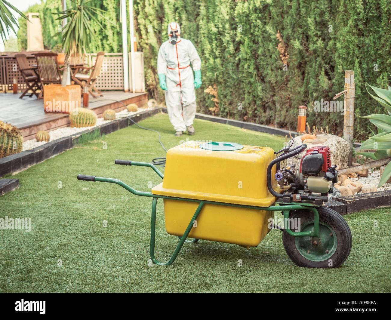 Professional worker in uniform for fumigation walking to equipment on ...