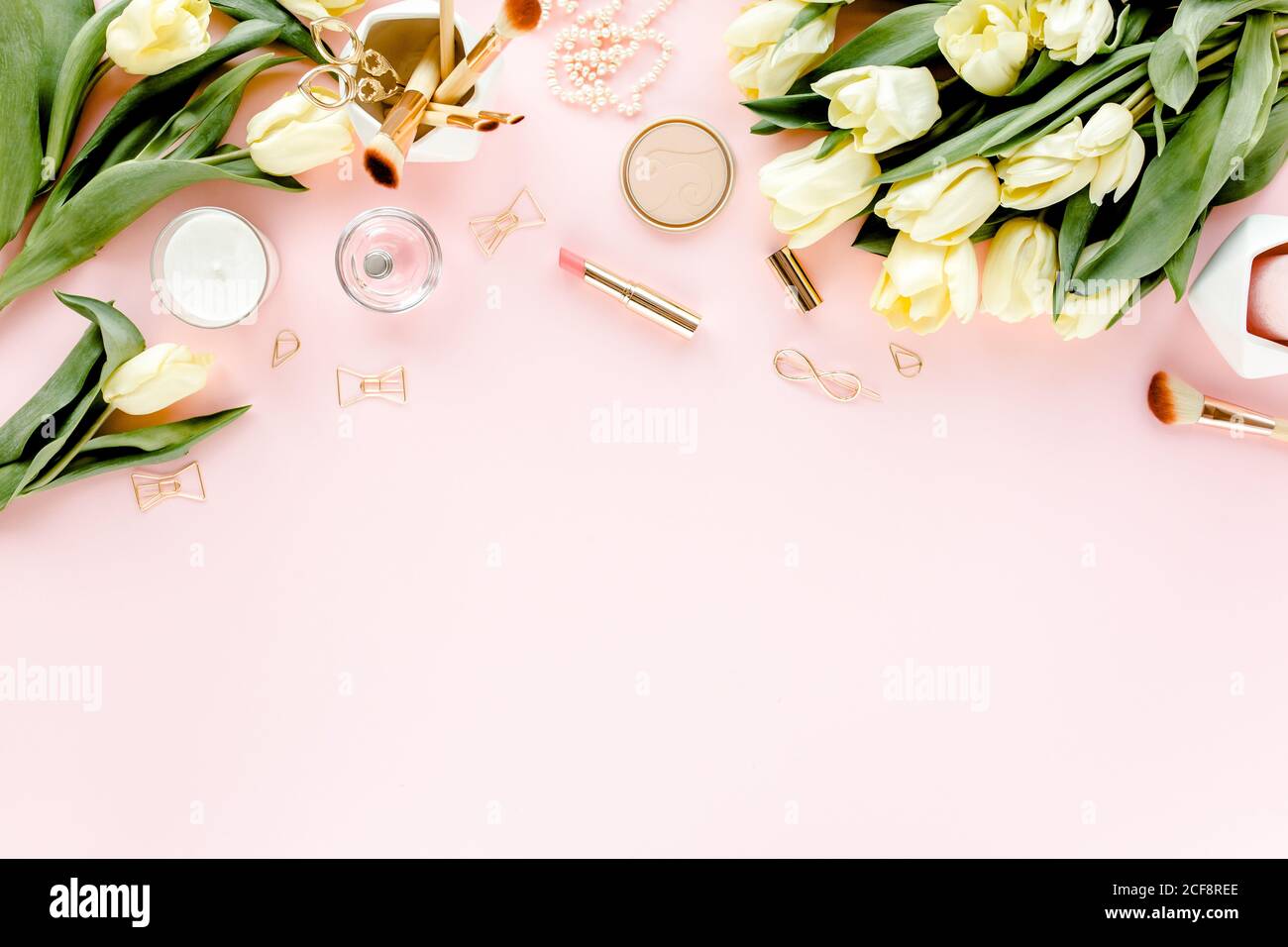 Female workspace with tulip flowers bouquet, golden accessories, diary ...