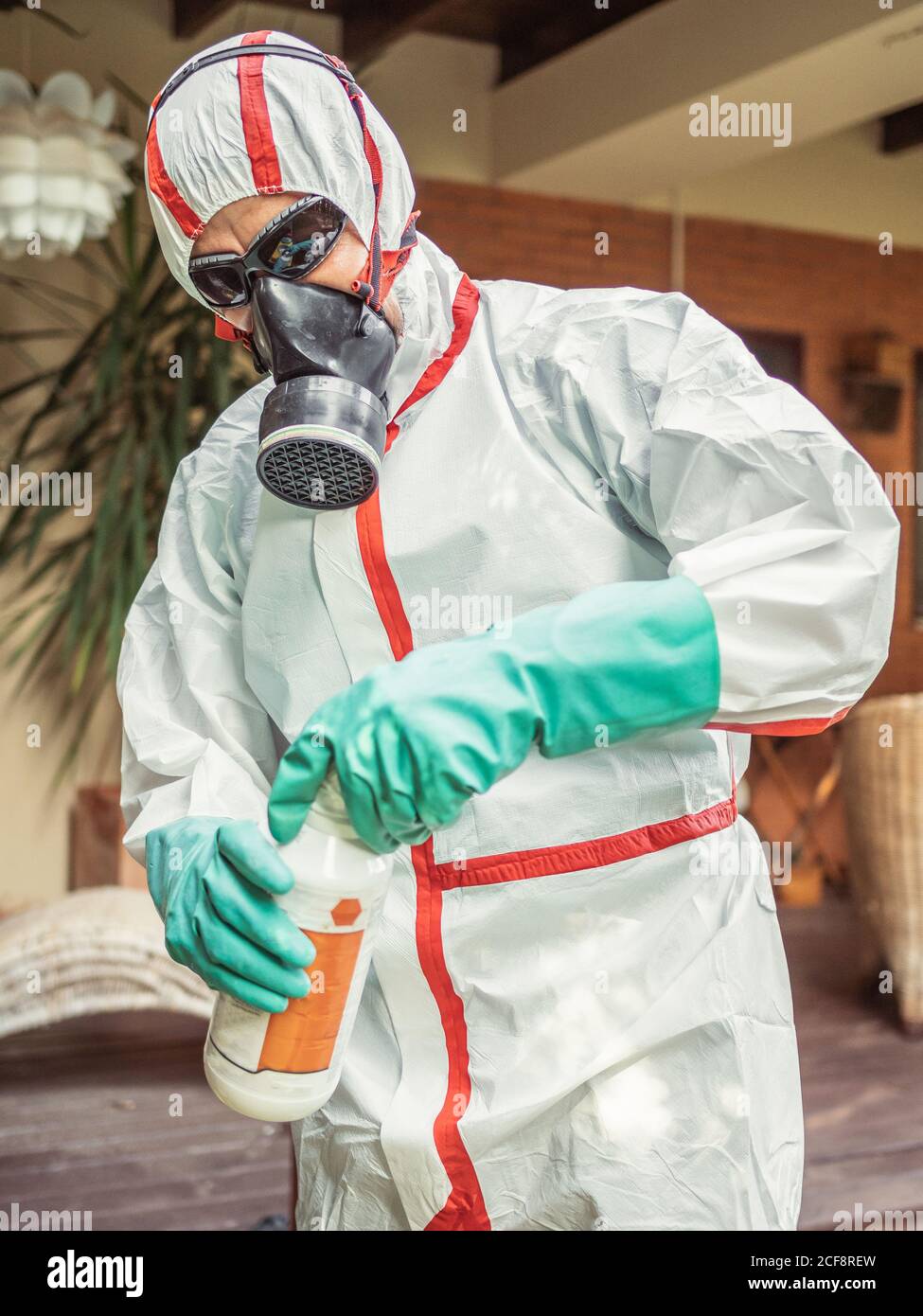 man in suit for fumigation pouring chemical into tank Stock Photo - Alamy