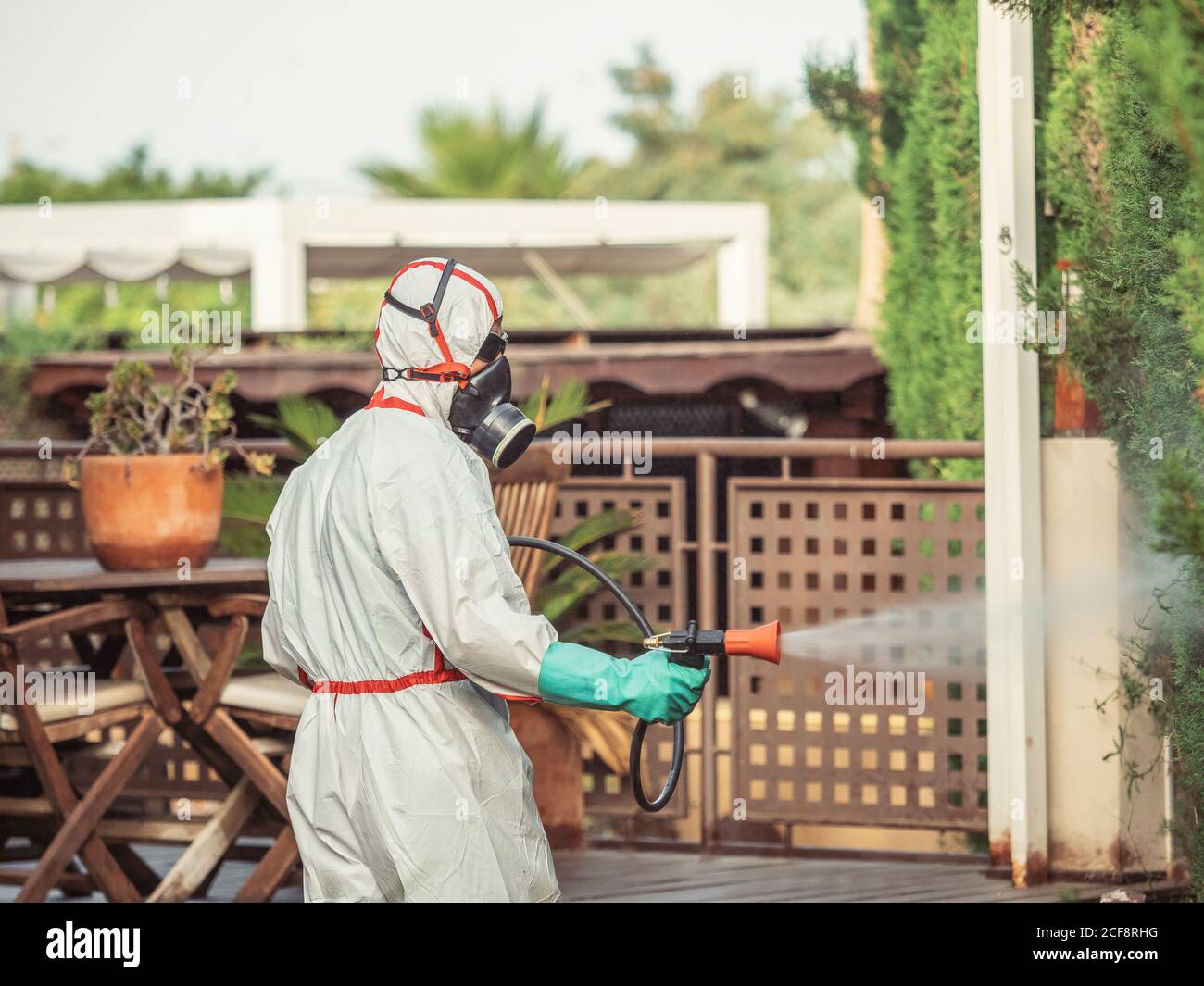 Fumigator in white uniform spraying substance on garden Stock Photo - Alamy