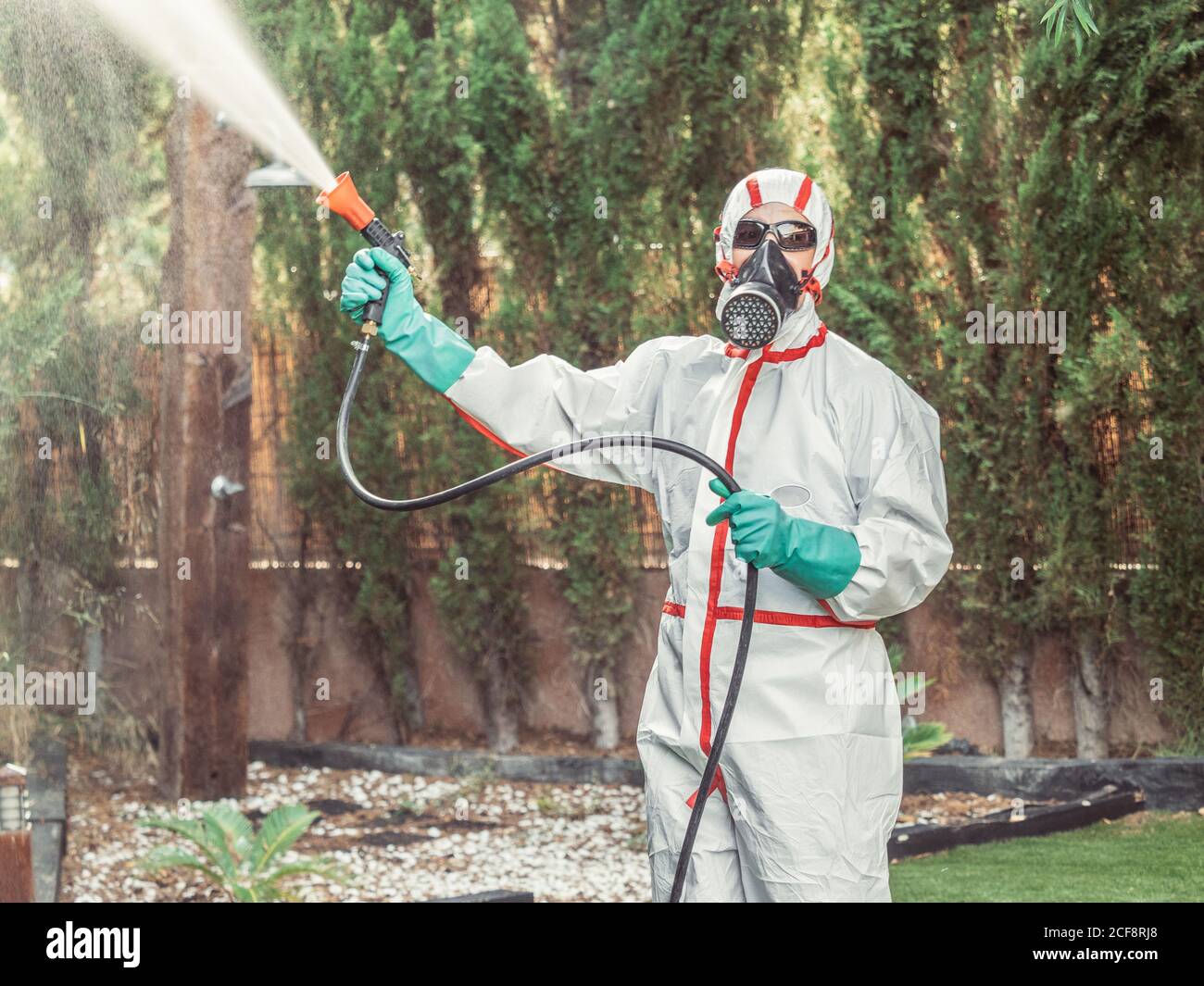 Fumigator in white uniform spraying substance on garden Stock Photo - Alamy