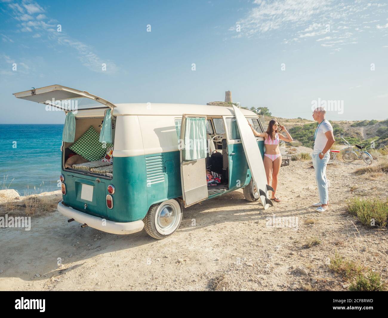 Side view of man and young Woman with surfboard talking near colorful ...