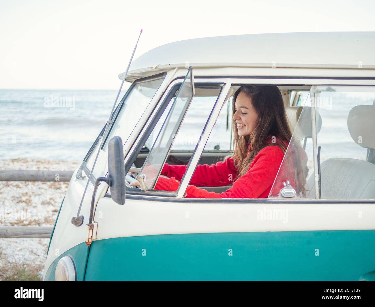 Side view of young Woman driving a vintage van at seaside Stock Photo ...