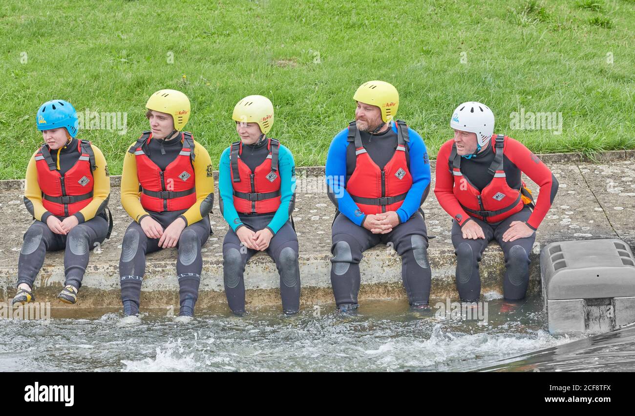 Family group sit on a bank at the Nene artificial whitewater course ...