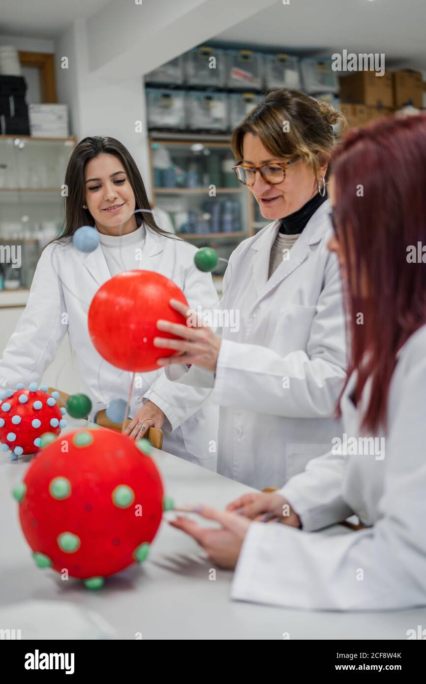 Female scientist and students examining molecule models in lab Stock ...