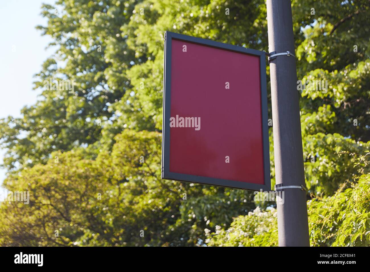 Red pole sign mock-up as pole advertising on a light pole in front of ...