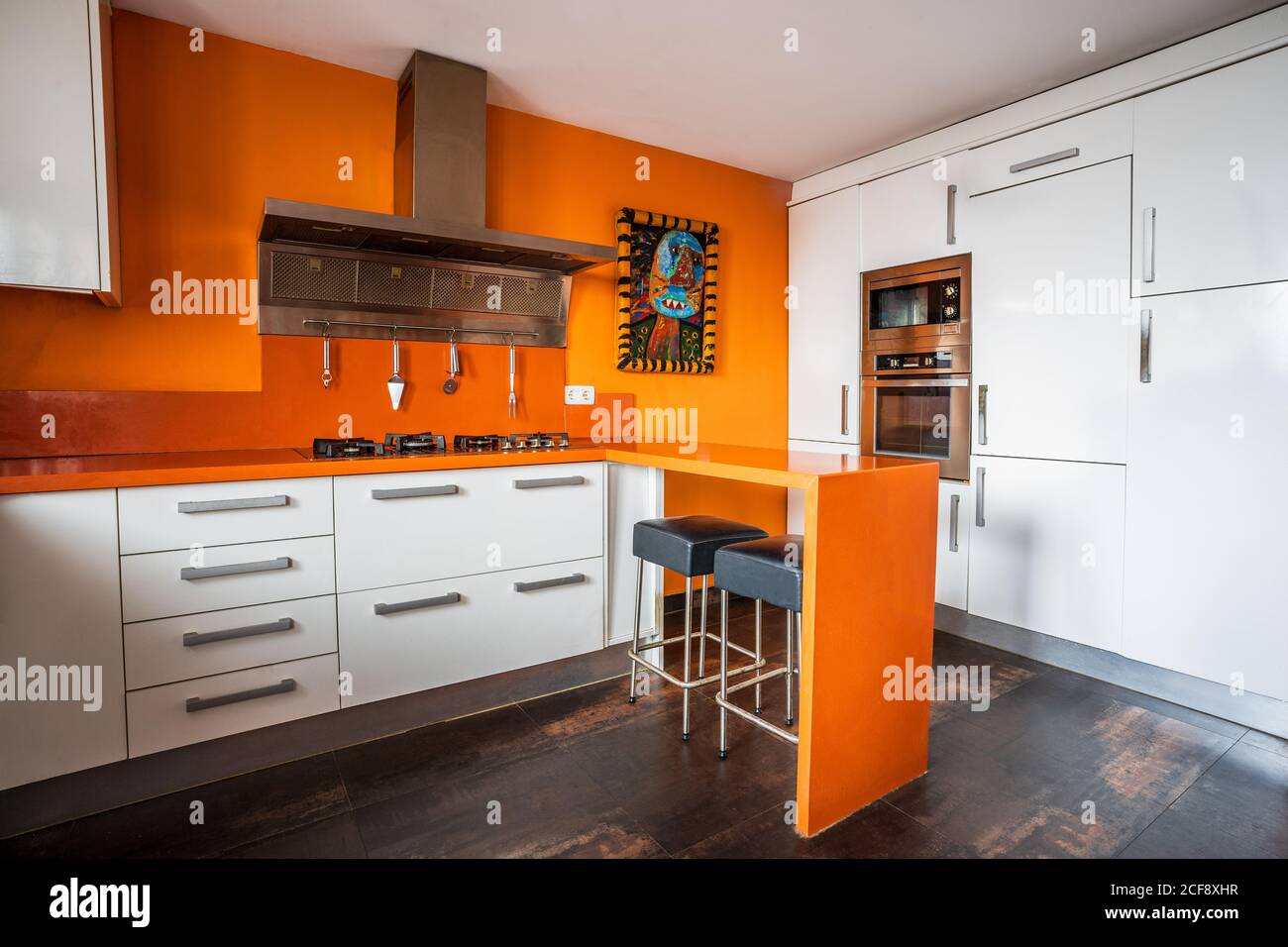 Contemporary kitchen interior with bright orange wall and counter ...