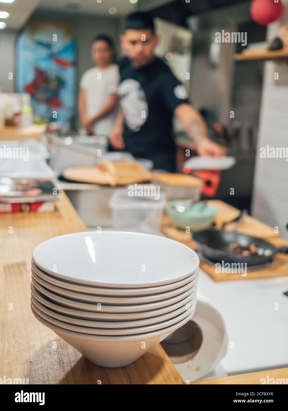 Stack of white bowls prepared for serving ramen on wooden counter and ...