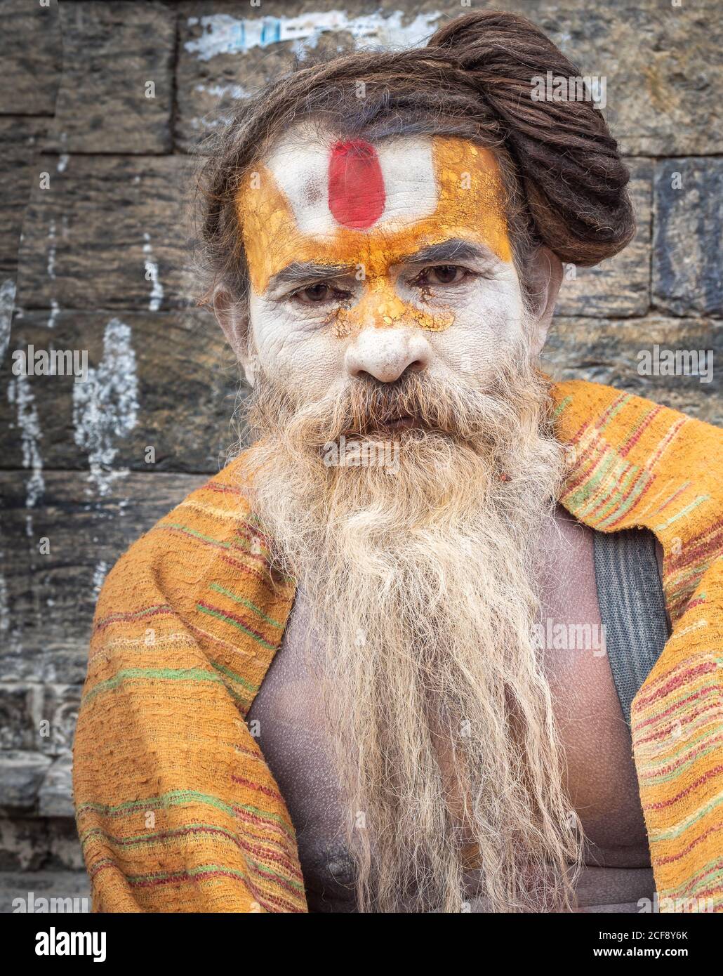 NEPAL, PASHUPATINATH TEMPLE - AUGUST 4, 2014: Aged shirtless sadhu with ...