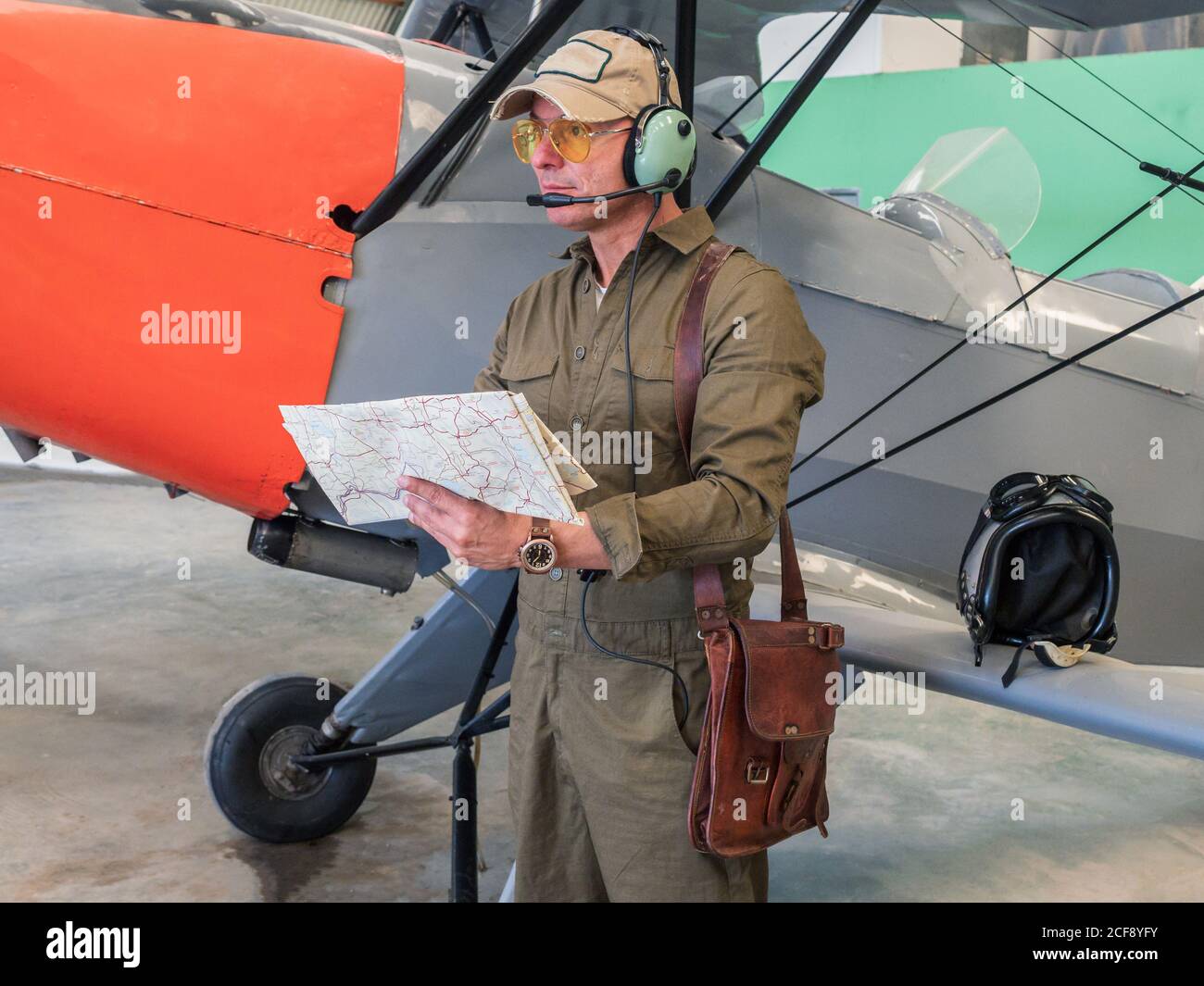 Pilot with map beside small plane Stock Photo - Alamy