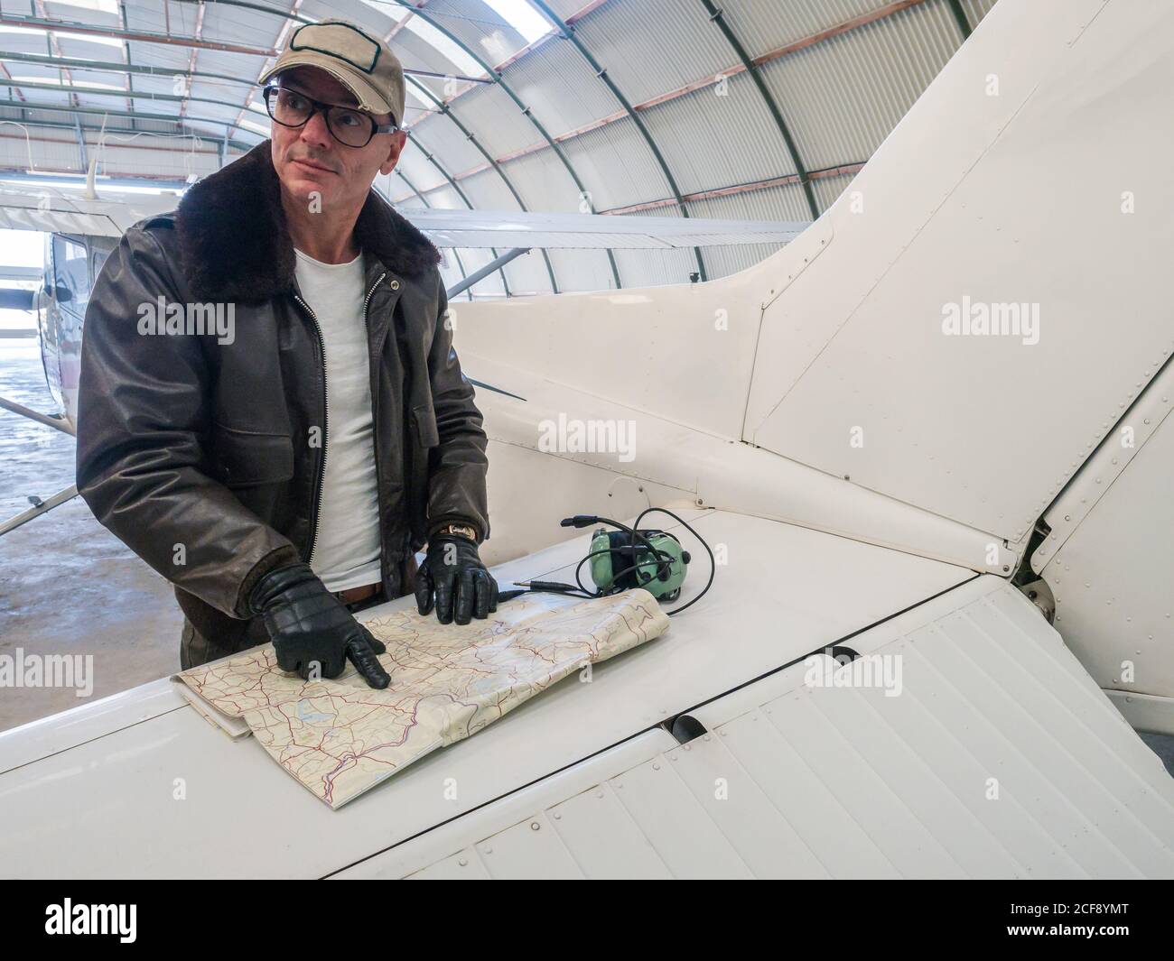 Pilot with map on small plane Stock Photo - Alamy
