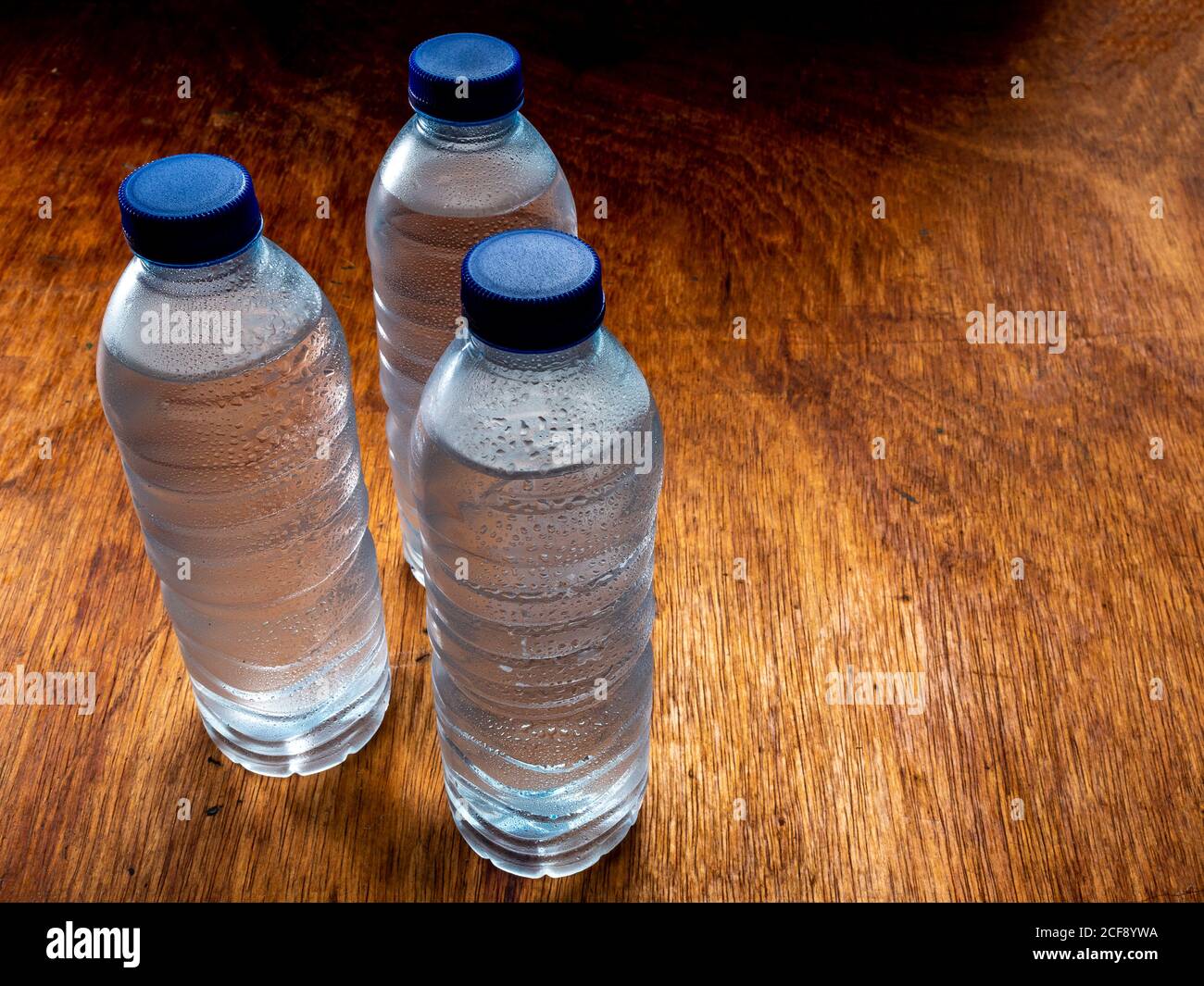 Group of very cold water bottles with blue caps and water drops Stock ...