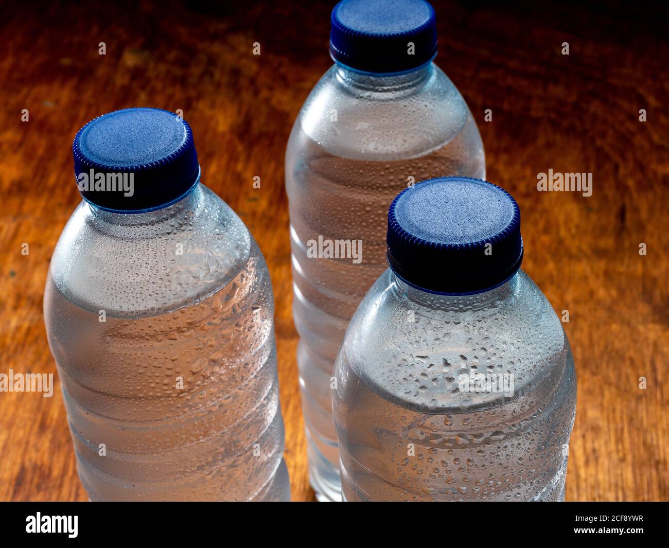 Group of very cold water bottles with blue caps and water drops Stock ...