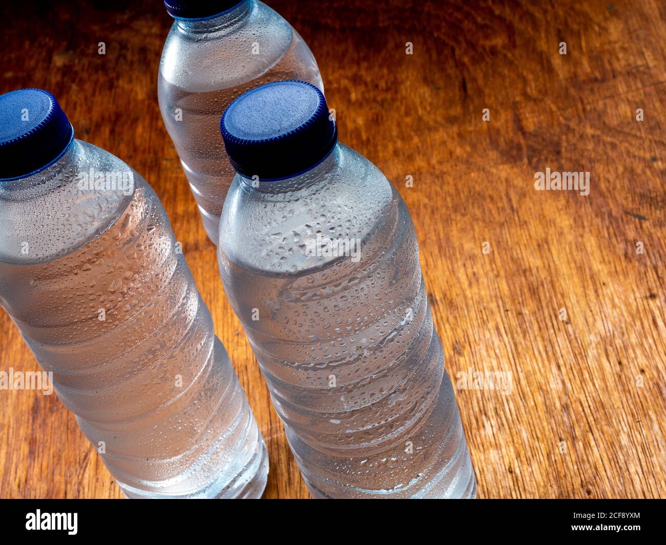 Group of very cold water bottles with blue caps and water drops Stock ...