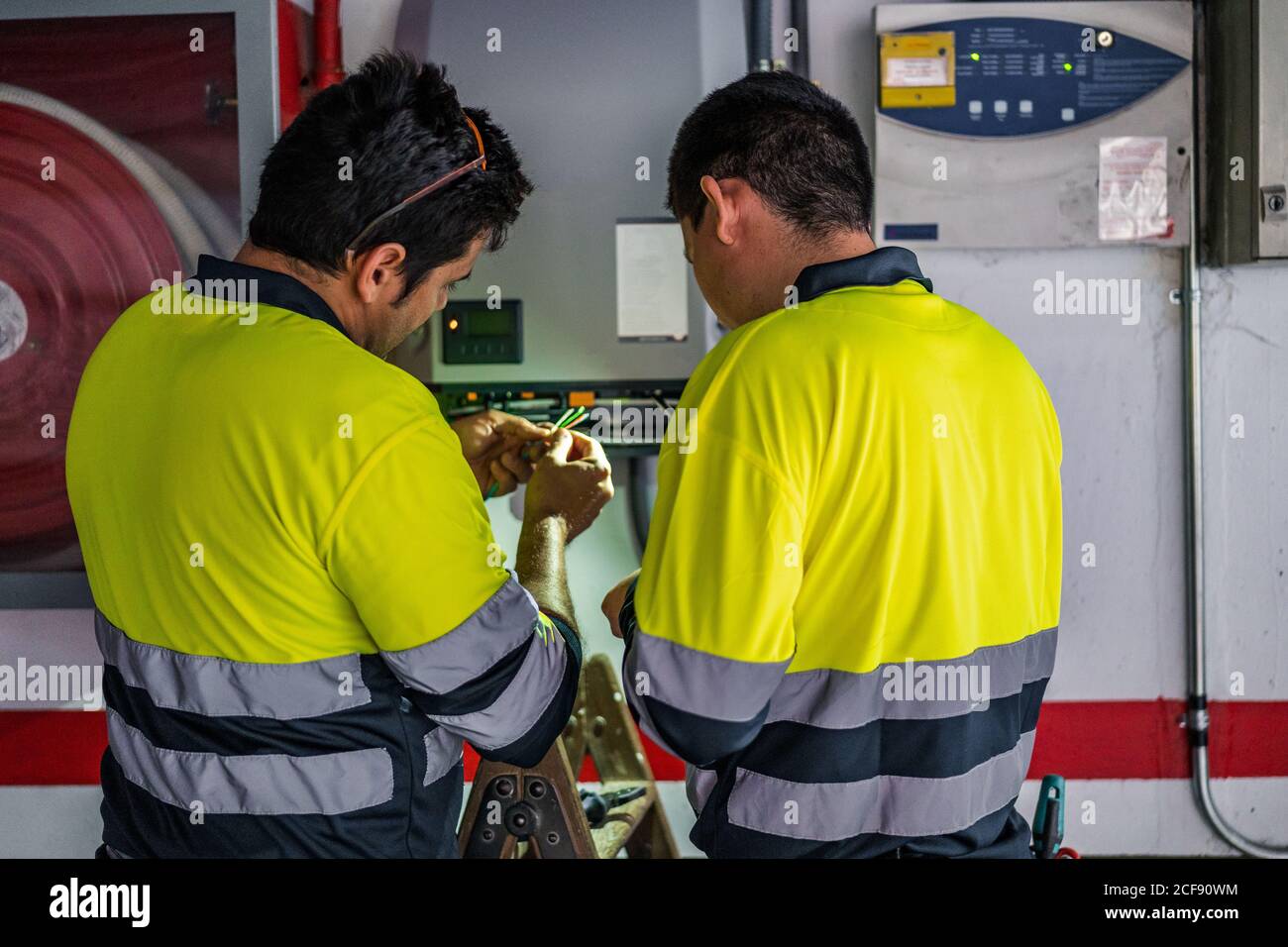 Back view of group of professional male technicians with electric tools ...