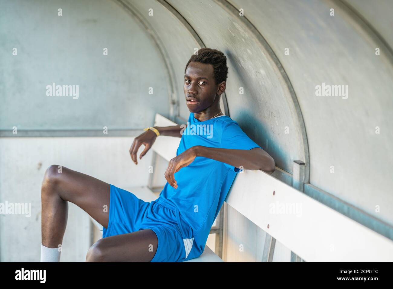 Black football player resting on bench Stock Photo - Alamy