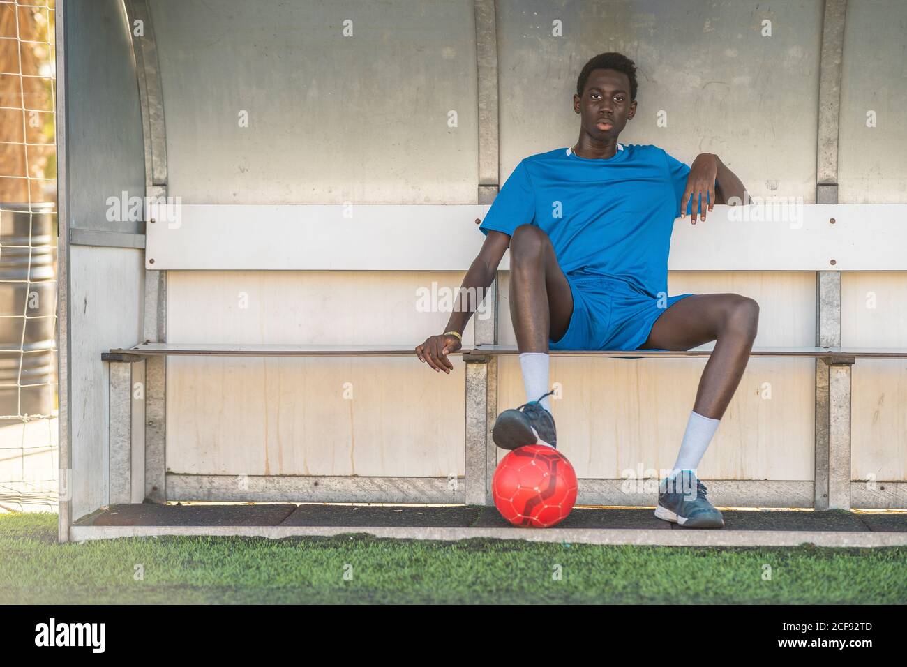 Black football player resting on bench Stock Photo - Alamy